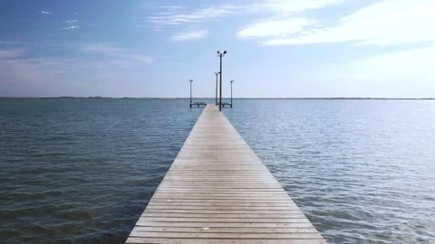 Long pier leading to the bay with street... | Stock Video | Pond5