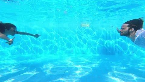 love in the pool - young couple swimming... | Stock Video | Pond5