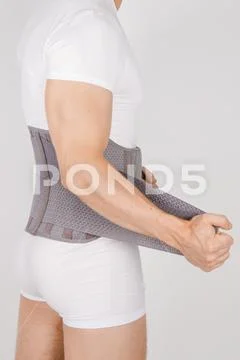 Lumbar brace on the human body isolated on a white background. Trauma ...