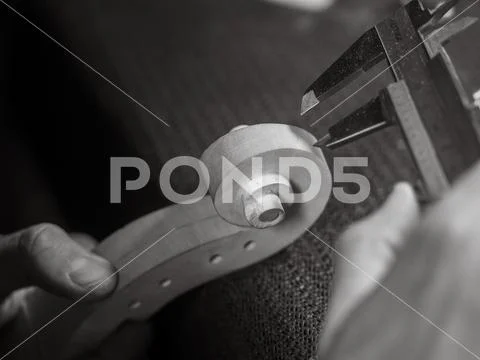 Luthier precision measuring the violin scroll thickness with meter ...