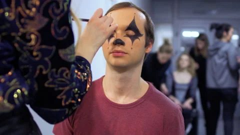 Make-up artist makes greasepaint to a yo... | Stock Video | Pond5