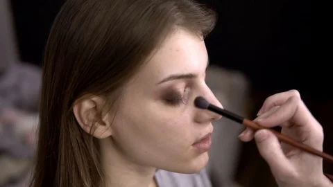 makeup artist puts a shadow on the model | Stock Video | Pond5