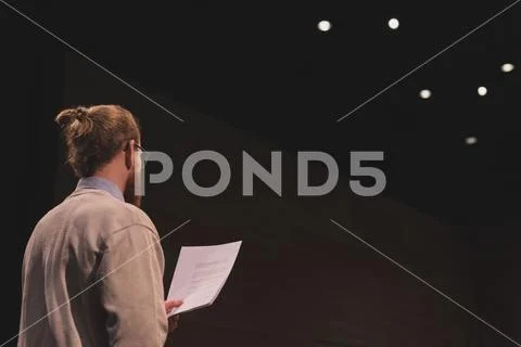 Male actor reading script on stage ~ Hi Res #92034603