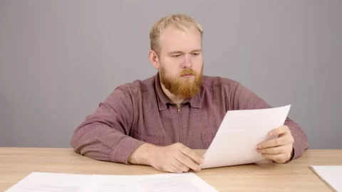 Male boss with beard sits at a table wit... | Stock Video | Pond5