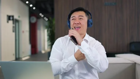 Male CEO listening music in headphones a... | Stock Video | Pond5