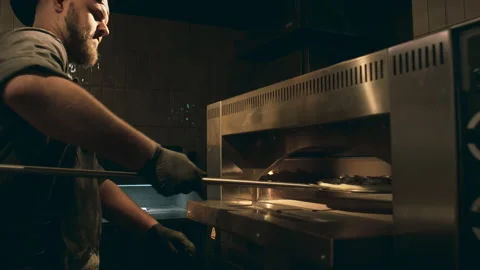 Male Chef Putting Pizza in Oven with Met... | Stock Video | Pond5