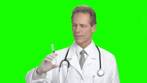 Male doctor with syringe on green screen... | Stock Video | Pond5