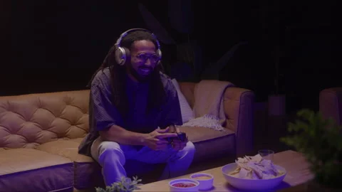 Male Gamer with Dreadlocks Sitting on th... | Stock Video | Pond5
