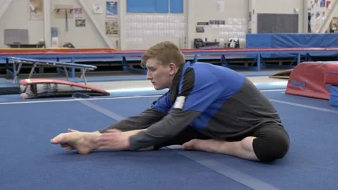 Male gymnast stretching in gymnasium | Stock Video | Pond5