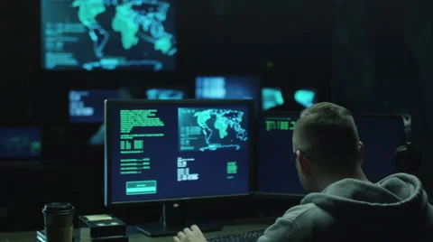 Male hacker in a hood works on a compute... | Stock Video | Pond5