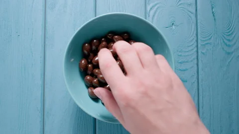 Male hand taking a handfull of chocolate... | Stock Video | Pond5
