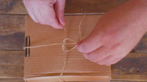 Male hands tying a rope on a cardboard b... | Stock Video | Pond5