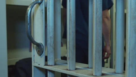 Male inmate sits down on his prison bunk... | Stock Video | Pond5