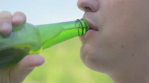 Male lips and neck of a beer bottle clos... | Stock Video | Pond5