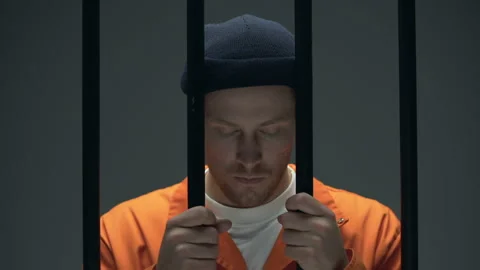 Male prisoner in despair closing face wi... | Stock Video | Pond5