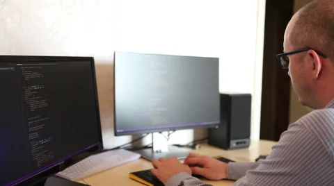 male programmer fixes the code sitting a... | Stock Video | Pond5