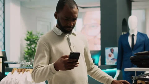 Male shopper trying to find clothes from... | Stock Video | Pond5