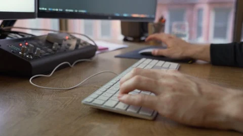 Male typing on a Mac computer in a moder... | Stock Video | Pond5