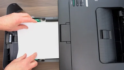 Man adding paper to a laser printer. | Stock Video | Pond5