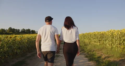 A man and a woman walk through a sunflow... | Stock Video | Pond5