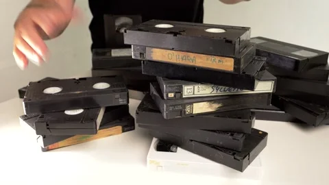 A man is arranging stacks of VHS tapes | Stock Video | Pond5