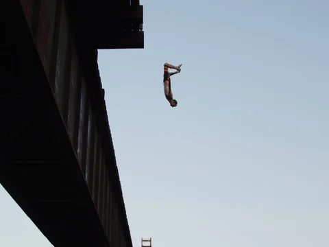 Man back flip off of an old abandoned br... | Stock Video | Pond5