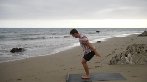 A man on the beach balancing in a calmin... | Stock Video | Pond5