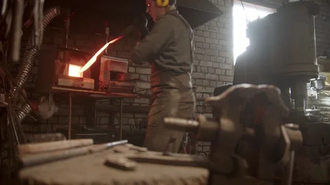 A man blacksmith forging a knife - putti... | Stock Video | Pond5