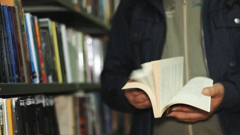 Man with book in library | Stock Video | Pond5