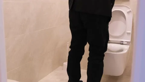 A man in business clothes urinates in th... | Stock Video | Pond5