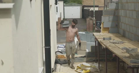 Man carrying breeze block over his shoul... | Stock Video | Pond5