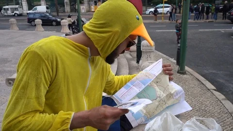 Man in a chicken costume read map | Stock Video | Pond5