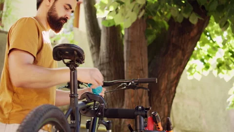 Man clamps bicycle frame to repair-stand | Stock Video | Pond5