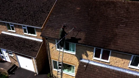 Man cleaning a house roof with soft wash... | Stock Video | Pond5