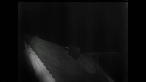 Man in cloak climbing on side of roof at... | Stock Video | Pond5