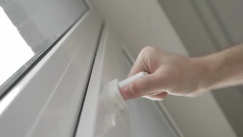 A man closes a PVC plastic window by tur... | Stock Video | Pond5