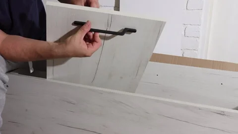 A man collects a bookcase. Fixes with bo... | Stock Video | Pond5