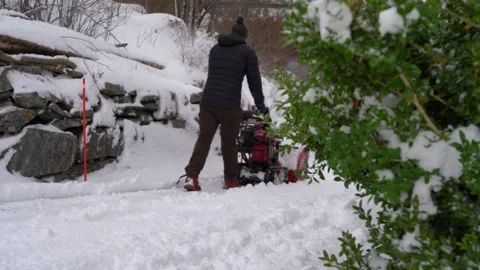 Man coming into frame using snowblower a... | Stock Video | Pond5