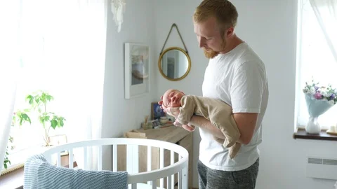man cradles a hand of a newborn baby | Stock Video | Pond5