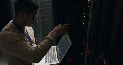 Man in data center with laptop, coding a... | Stock Video | Pond5