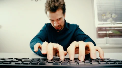 Man doing funny faces while typing on ke... | Stock Video | Pond5