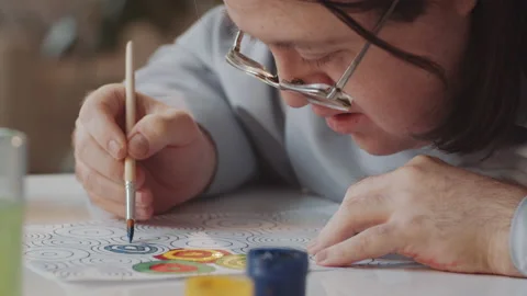 Man with Down Syndrome Drawing on Paper ... | Stock Video | Pond5