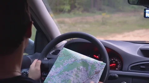 man is driving a car, looking at paper m... | Stock Video | Pond5