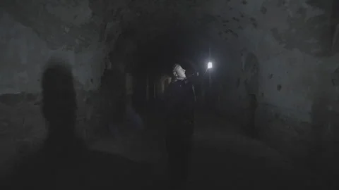 A man in a dungeon, holding a lamp. Expl... | Stock Video | Pond5