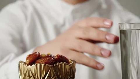 Man eating dates with water, praying, is... | Stock Video | Pond5