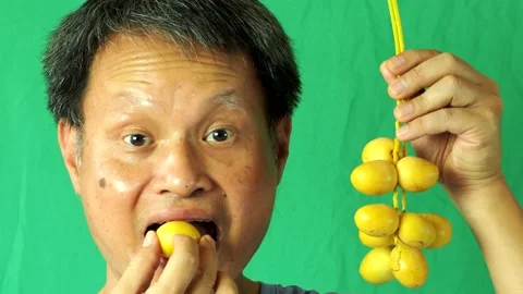 Man is eating fresh dates, with green ba... | Stock Video | Pond5