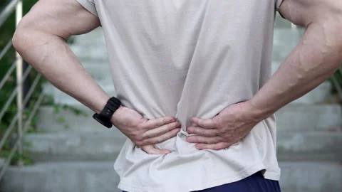 A man feels a sharp pain in his lower ba... | Stock Video | Pond5