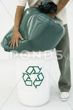 Man forcing large garbage bag into recycling bin, cropped view Stock ...
