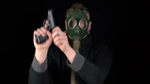 A man in a gas mask stands with a gun. T... | Stock Video | Pond5
