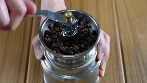 Man grinding coffee beans using a manual... | Stock Video | Pond5